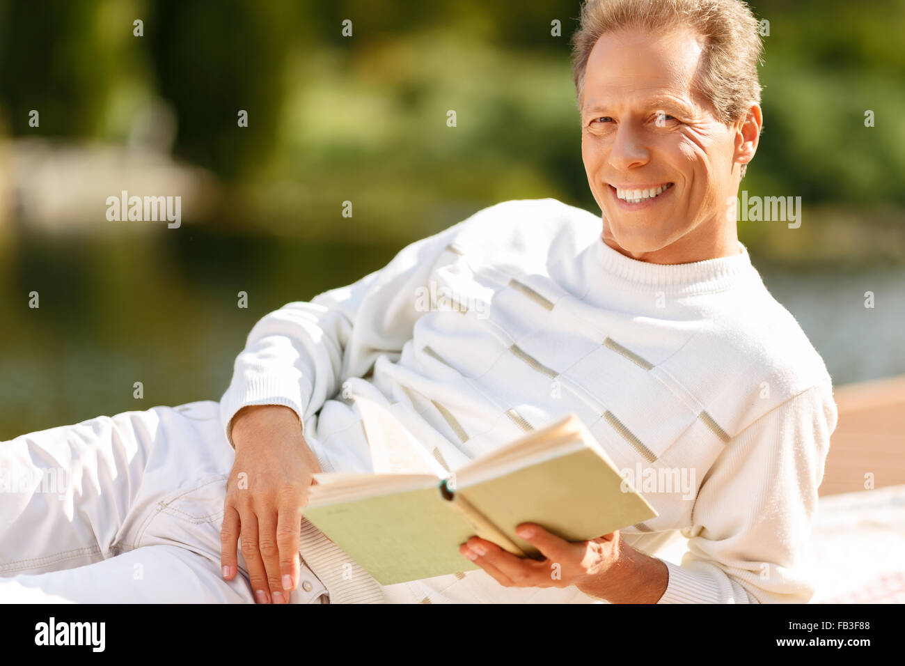 Agreeable man reading a book Stock Photo - Alamy