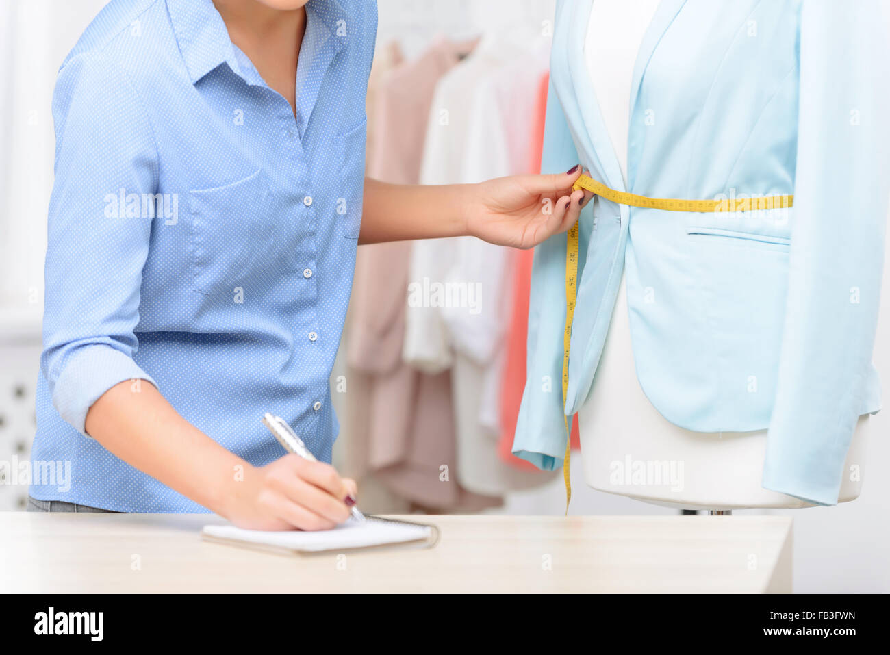 Pleasant designer making clothes Stock Photo - Alamy
