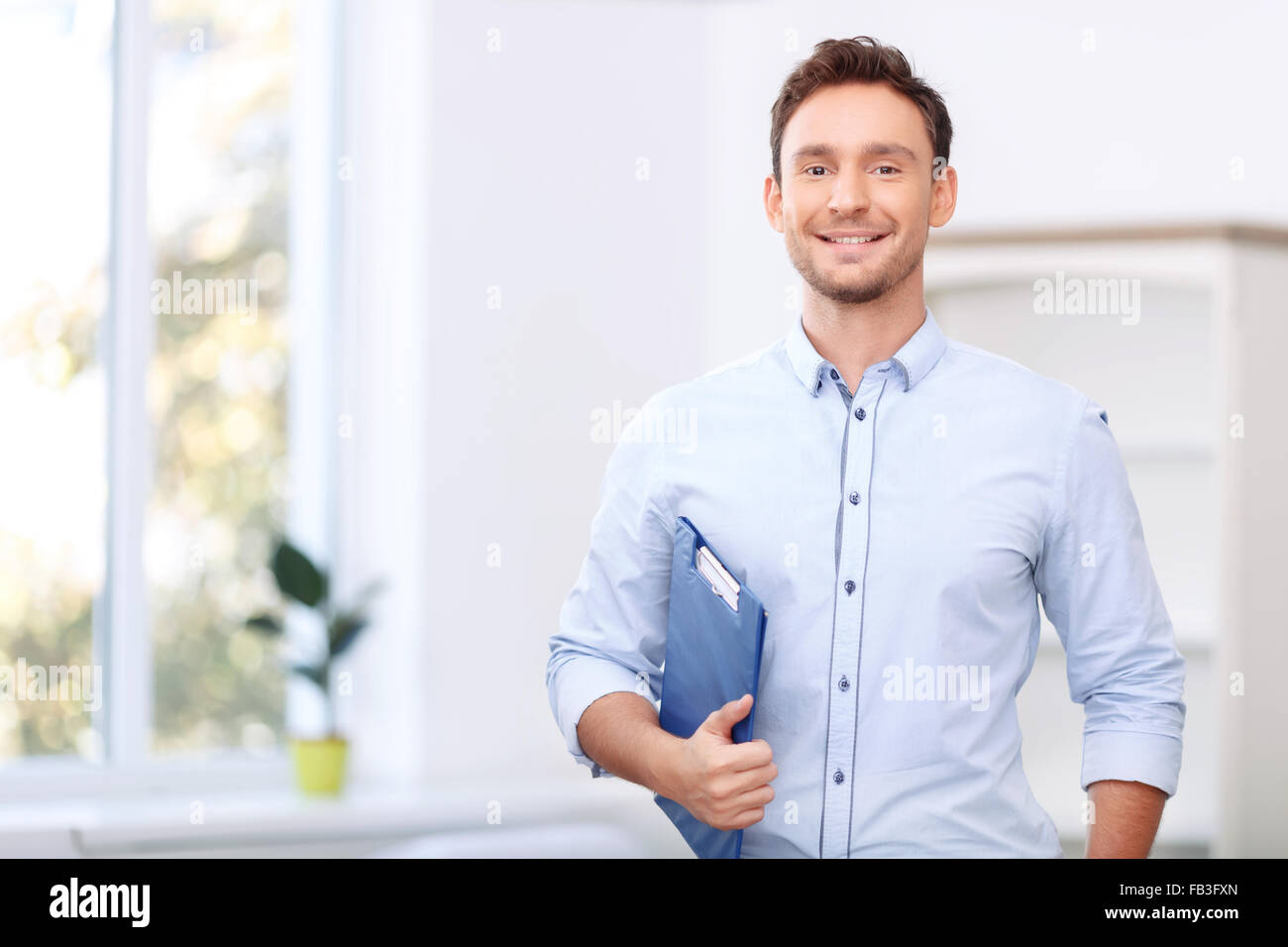 Nice realtor holding folder Stock Photo - Alamy