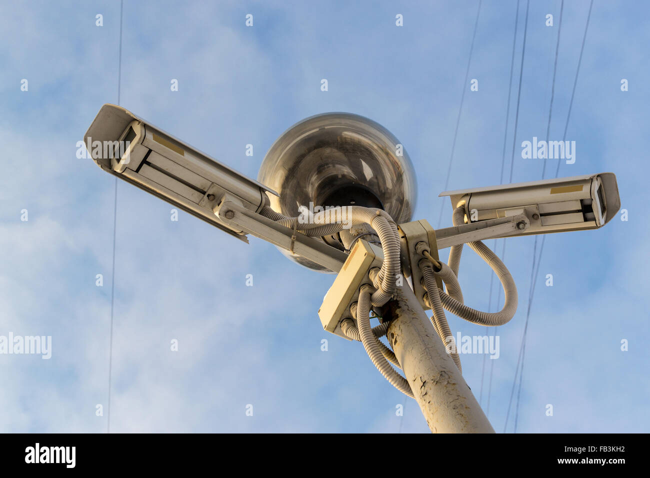 Two CCTV Cameras pointing in opposite directions with a bulb style ...