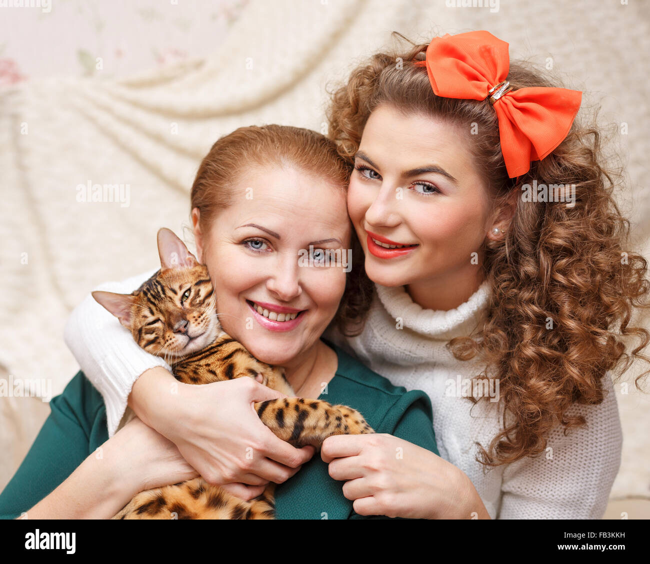 Mother, daughter and a cat. Embrace with a pet. Bengal cat Stock Photo ...