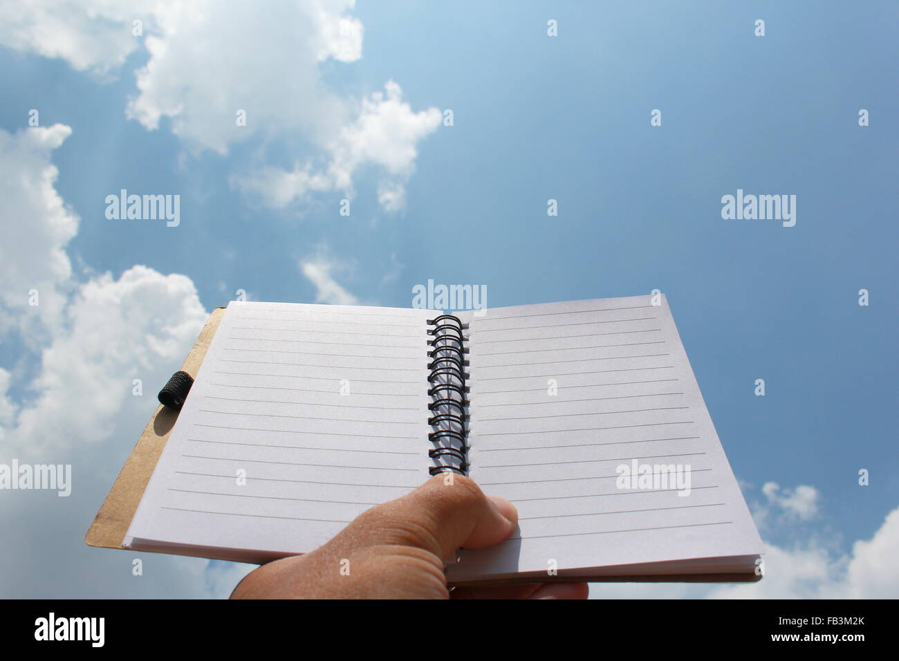 two page notebook in hand on the background of sky during daytime Stock ...