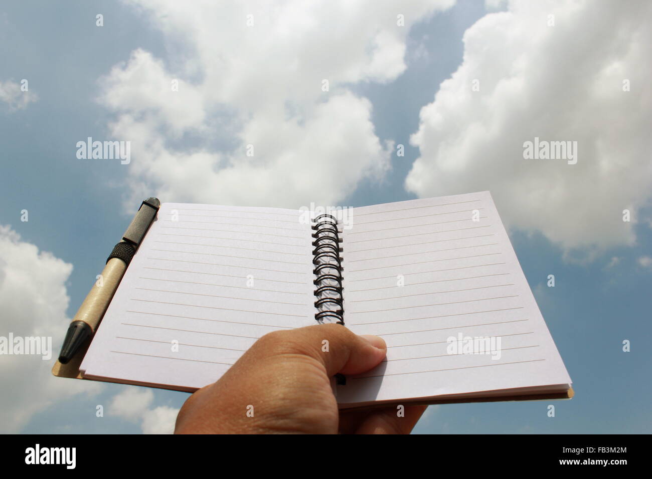 two page notebook in hand on the background of sky during daytime Stock ...