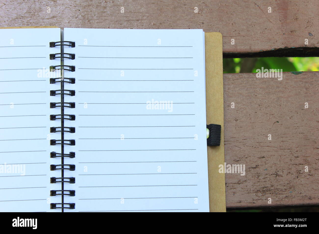 notebook on the brown bench during daytime Stock Photo - Alamy