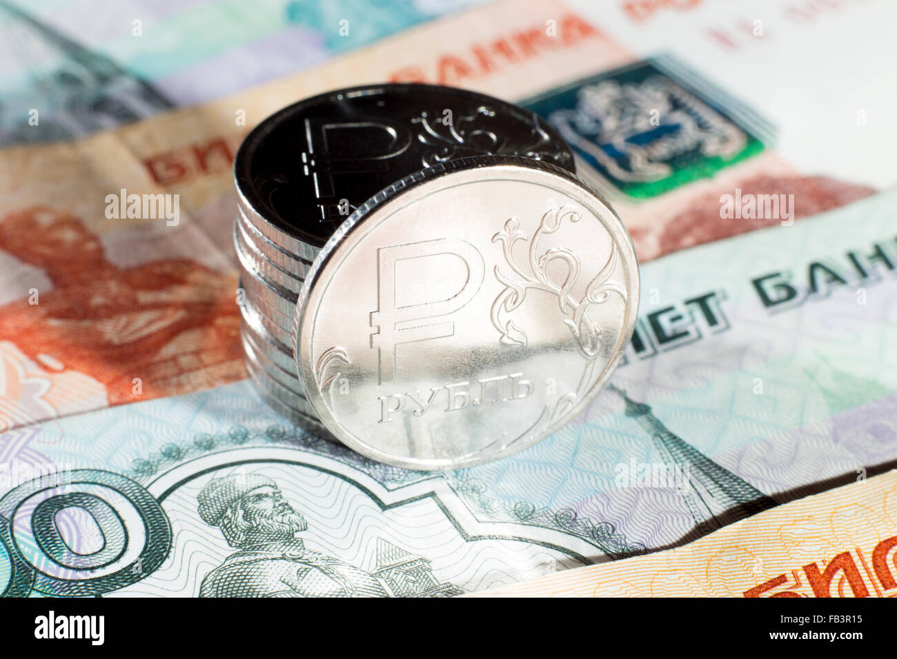 Several metal coins of one ruble standing on Russian paper banknotes ...
