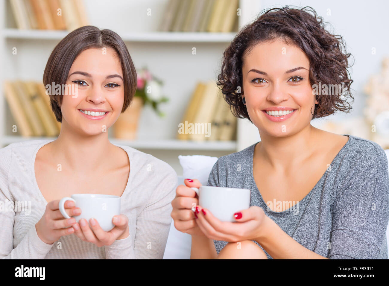 Two young ladies are having tea time Stock Photo - Alamy