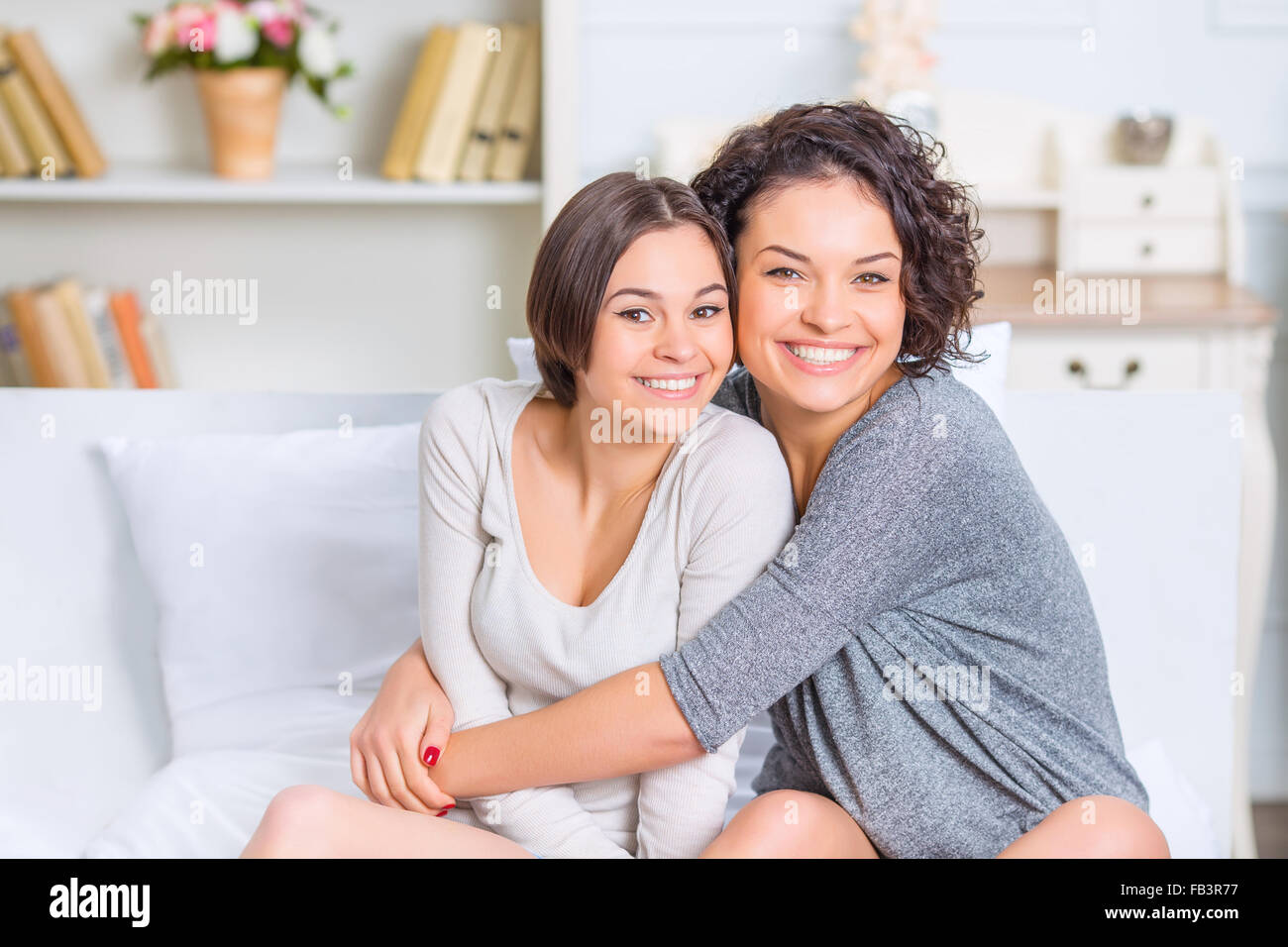 One sister hugging another Stock Photo - Alamy