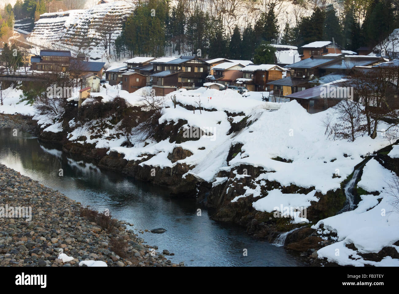 Village by the river covered with snow in the mountain, Shirakawa-go ...