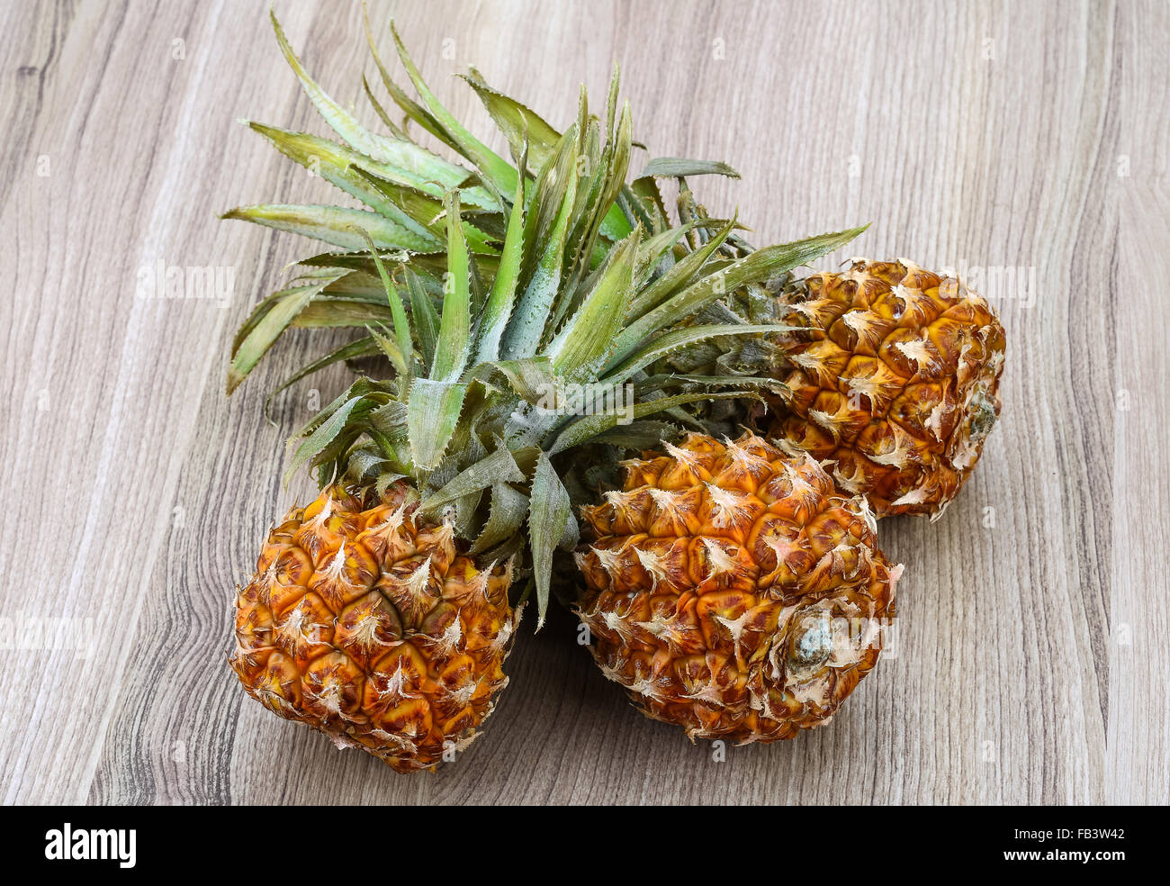 Fresh ripe Small pineapples on the wood background Stock Photo - Alamy