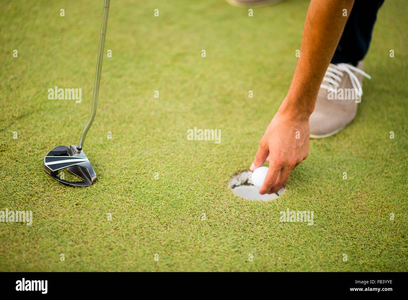 Golf ball, putter and boy's legs on green Stock Photo - Alamy