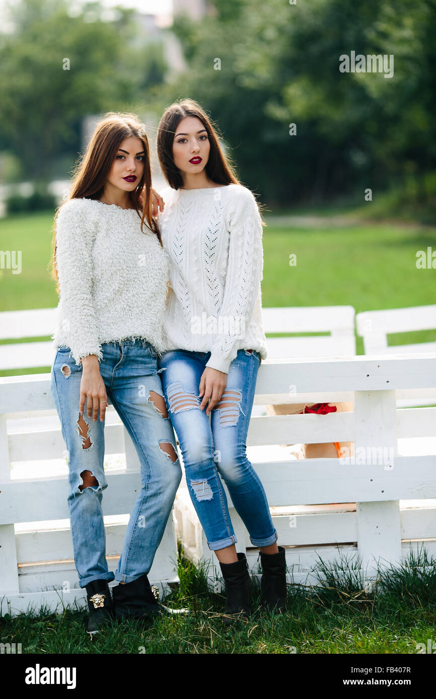 Two girls lean bench Stock Photo - Alamy
