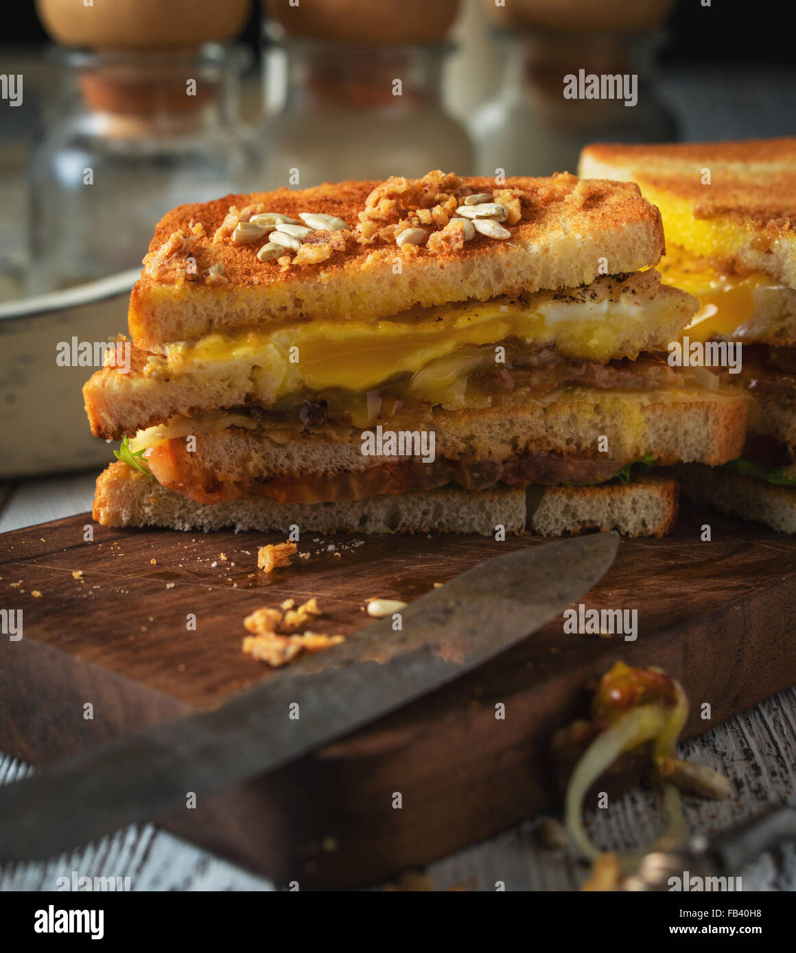 Sandwich with egg, tomato, onions and bacon on a vintage wooden ...