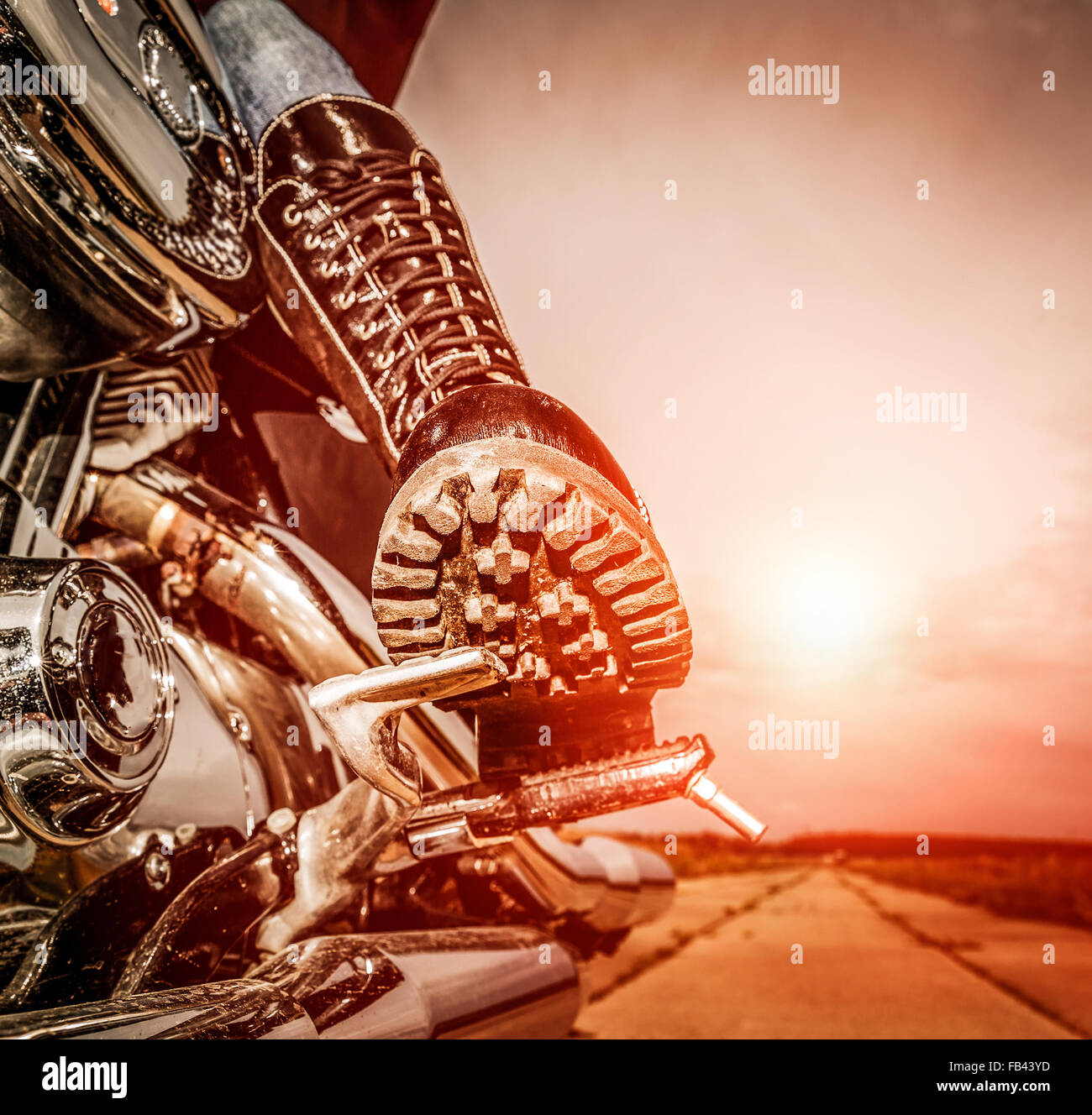 Biker girl riding on a motorcycle. Bottom view of the legs in leather ...