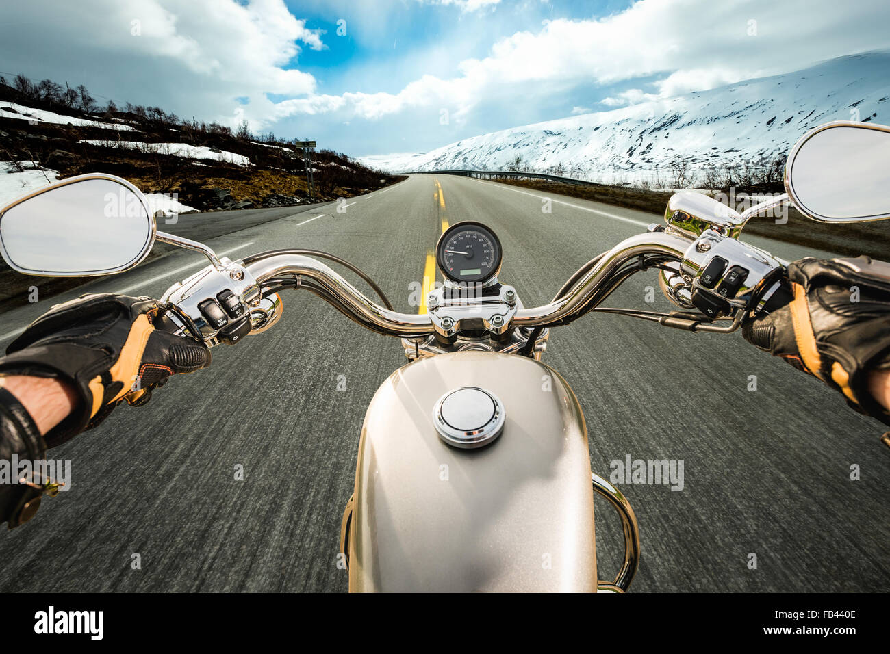 Biker driving a motorcycle rides along the asphalt road. First-person ...