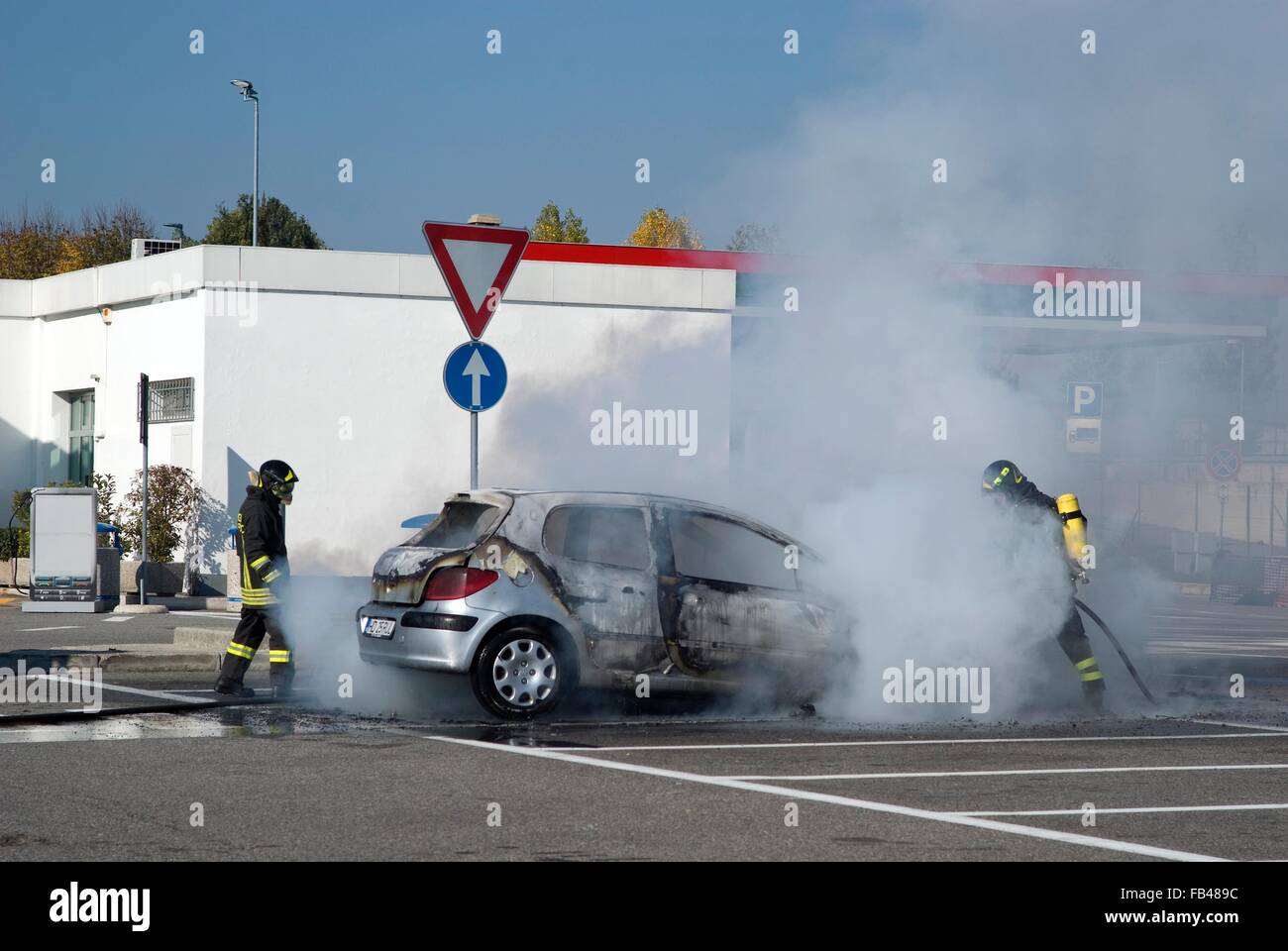 Firemen extinguishing a car fire Stock Photo - Alamy