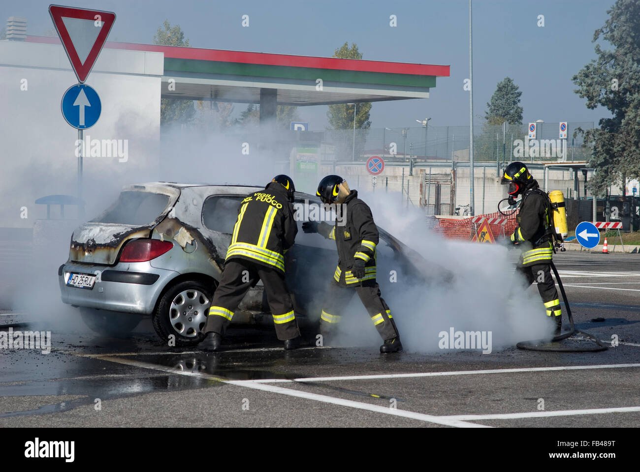 Firemen extinguishing a car fire Stock Photo - Alamy