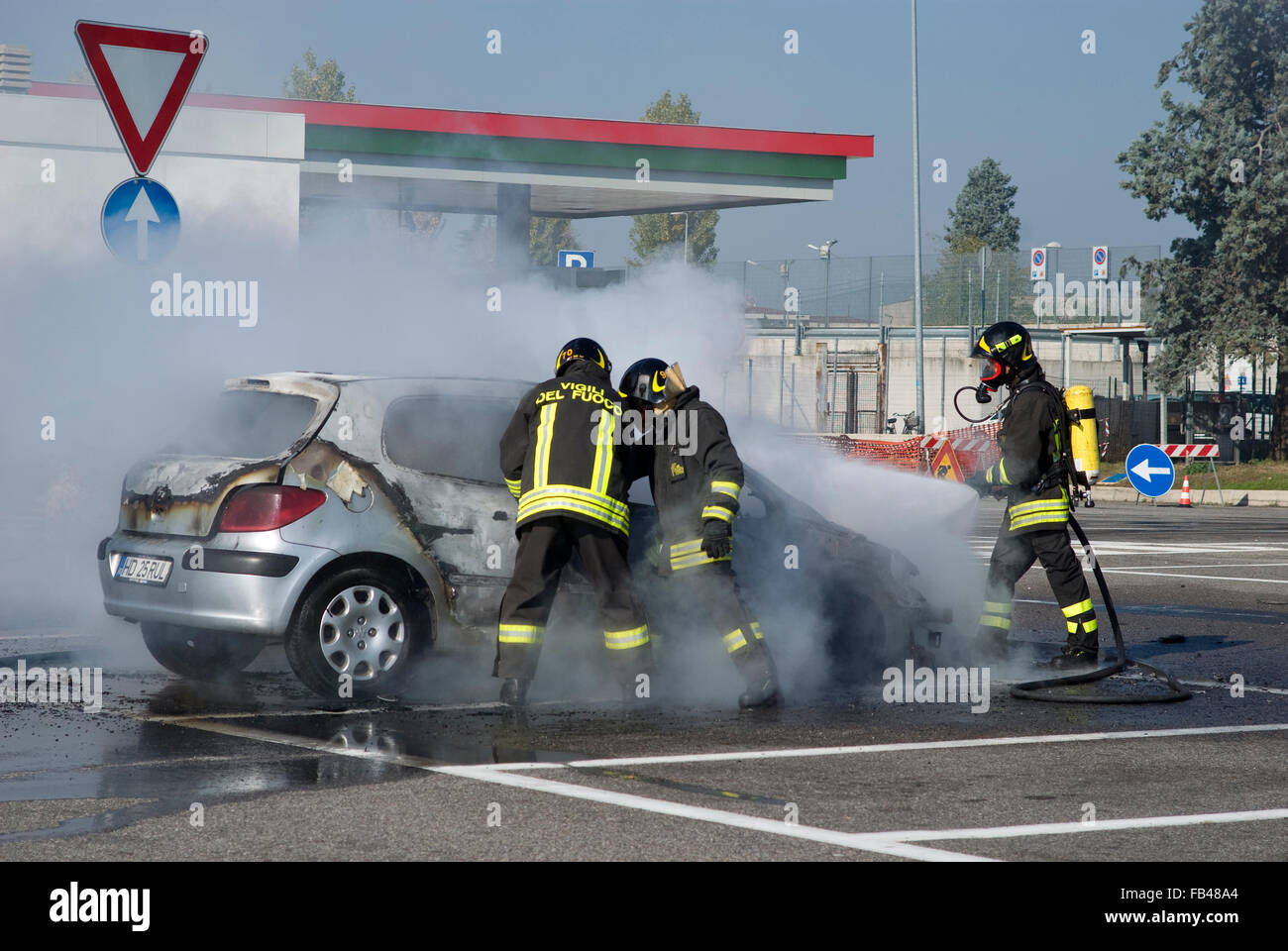 Firemen extinguishing a car fire Stock Photo - Alamy