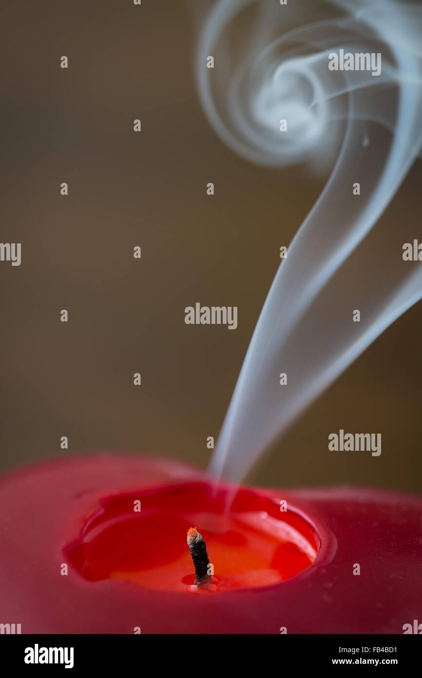 Extinguished red candle with smoke Stock Photo - Alamy