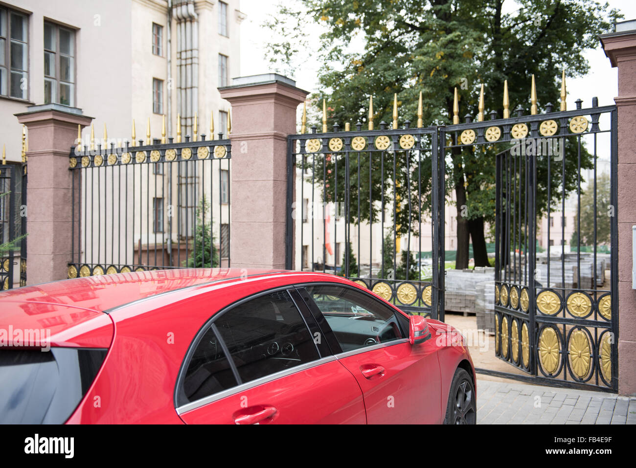 A red, stylist car parked in front of an office building on ...