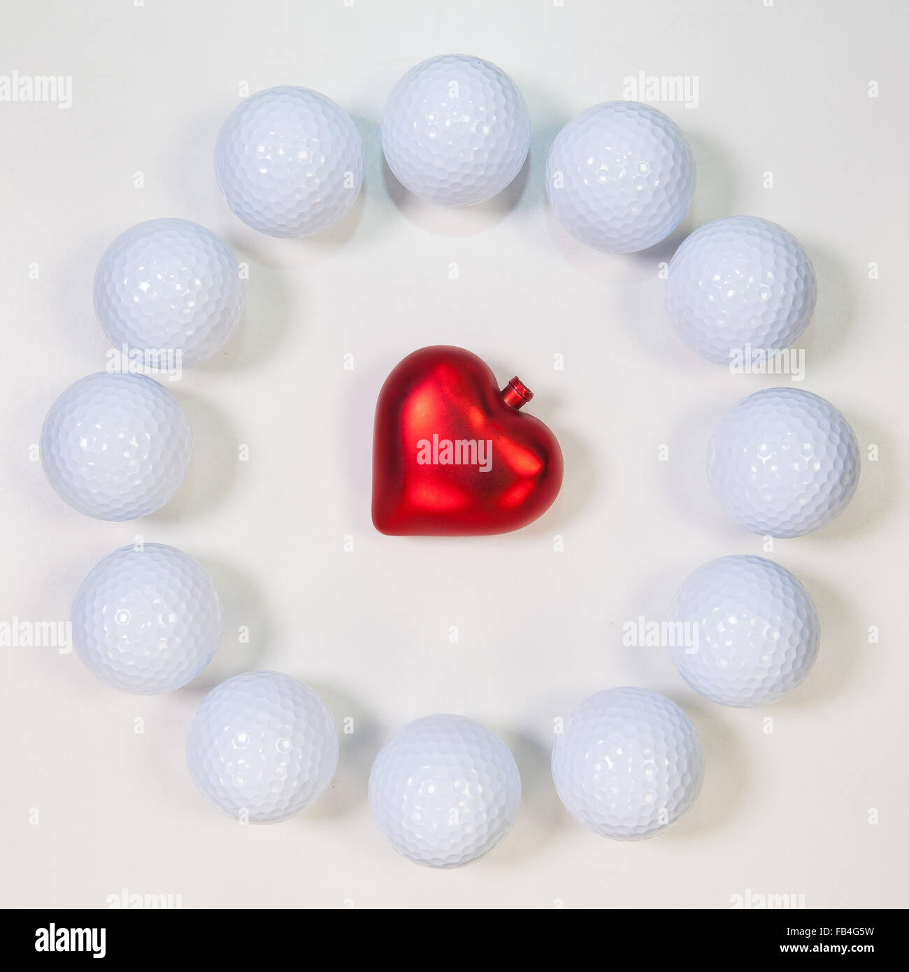The circle of golf balls and red heart Stock Photo - Alamy