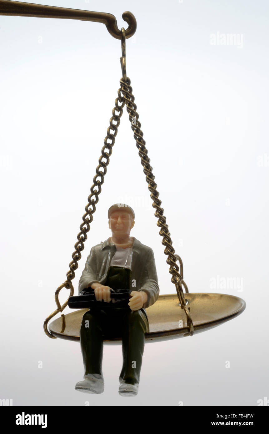 Man sitting on a golden weighing scale or balance Stock Photo - Alamy