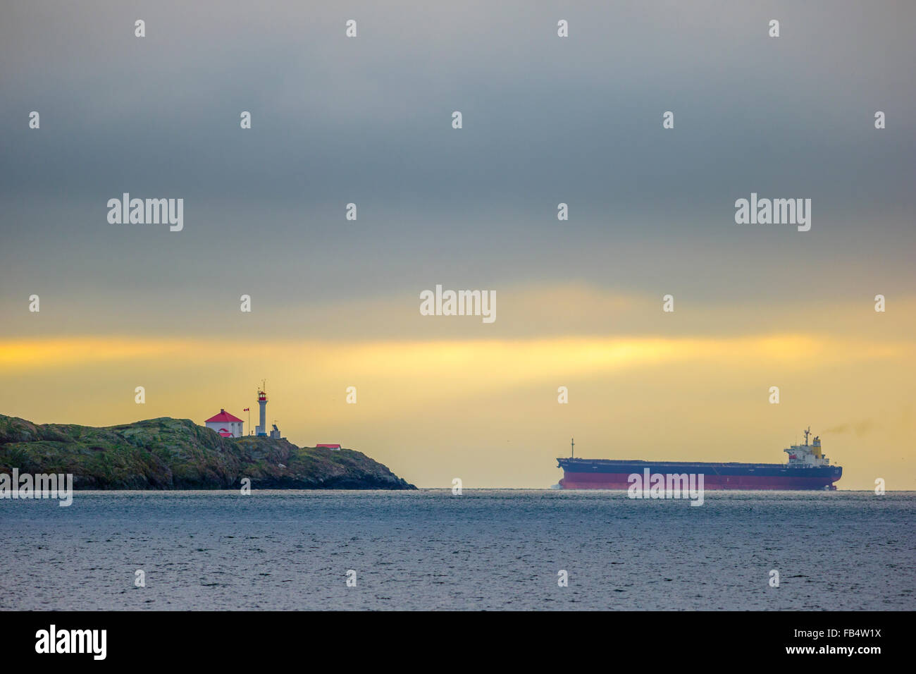 Freighter in Stait of Juan de Fuca at sunset passing by Trial Island ...