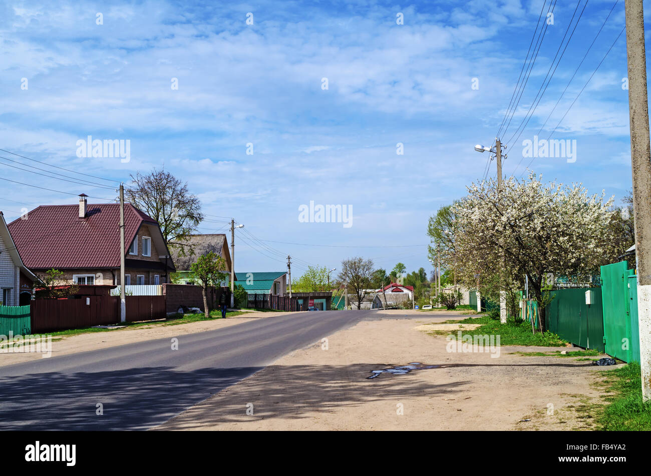 Spring village landscape. Asphalt road, houses and gardens Stock Photo ...