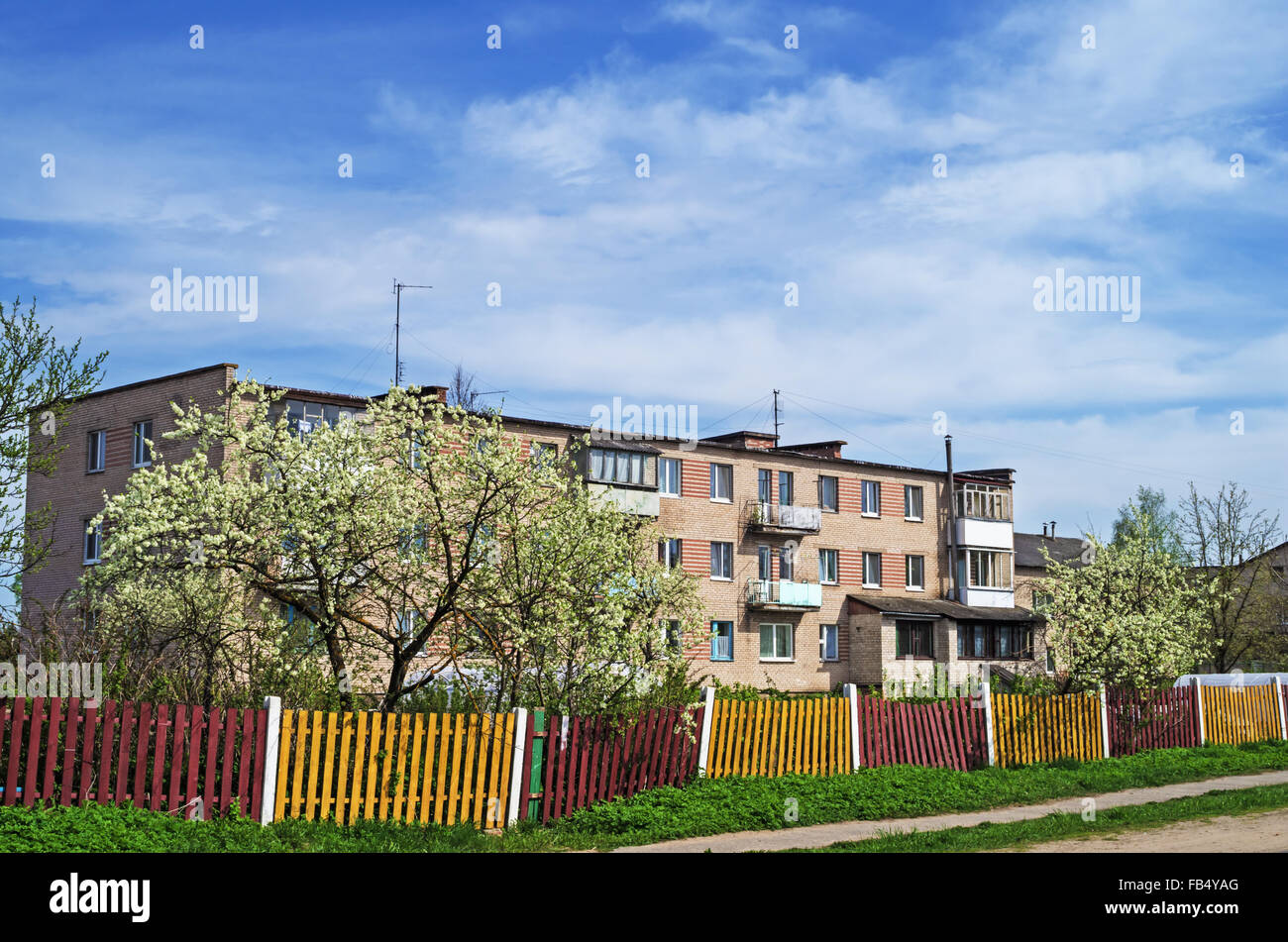 Spring village landscape. Brick three-storyed house of 1970, wooden ...