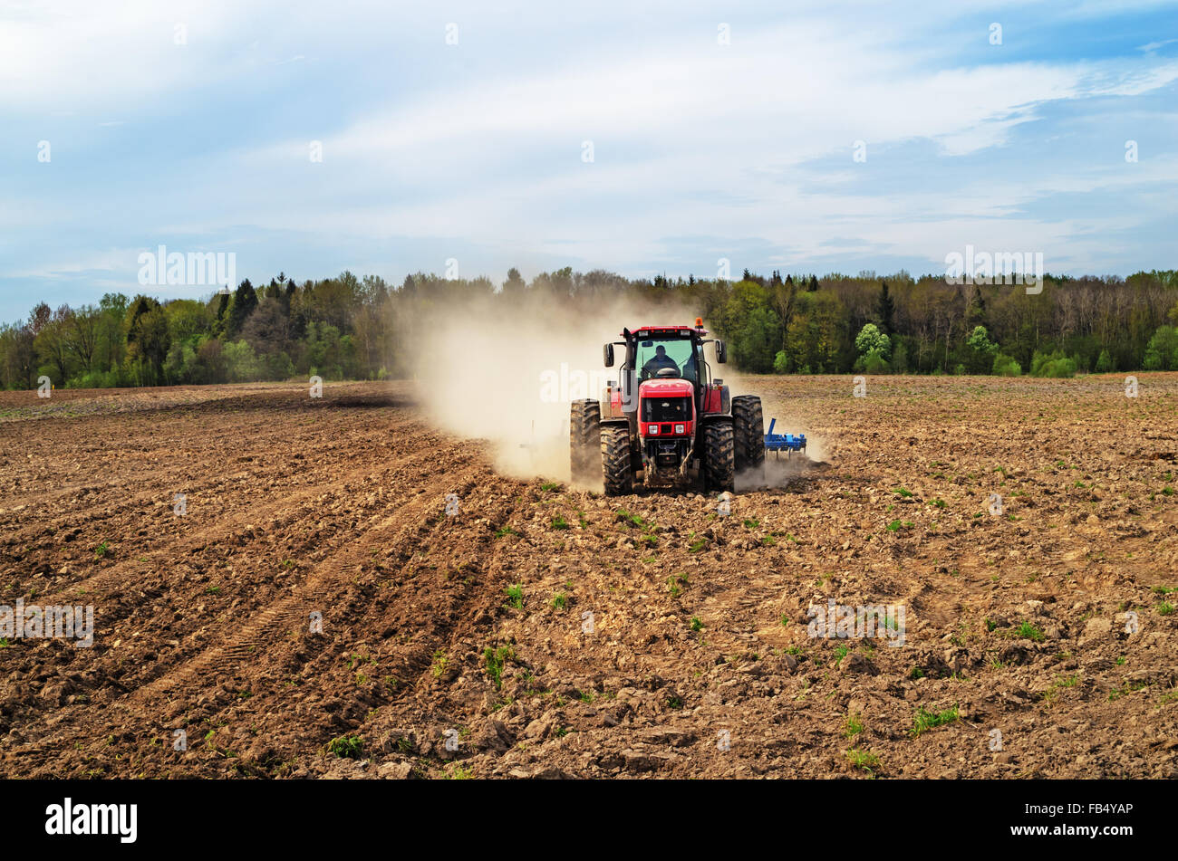 The tractor works at an agricultural field Stock Photo - Alamy