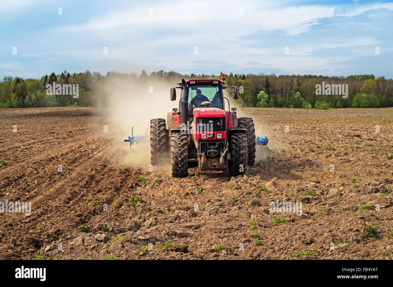The tractor works at an agricultural field Stock Photo - Alamy