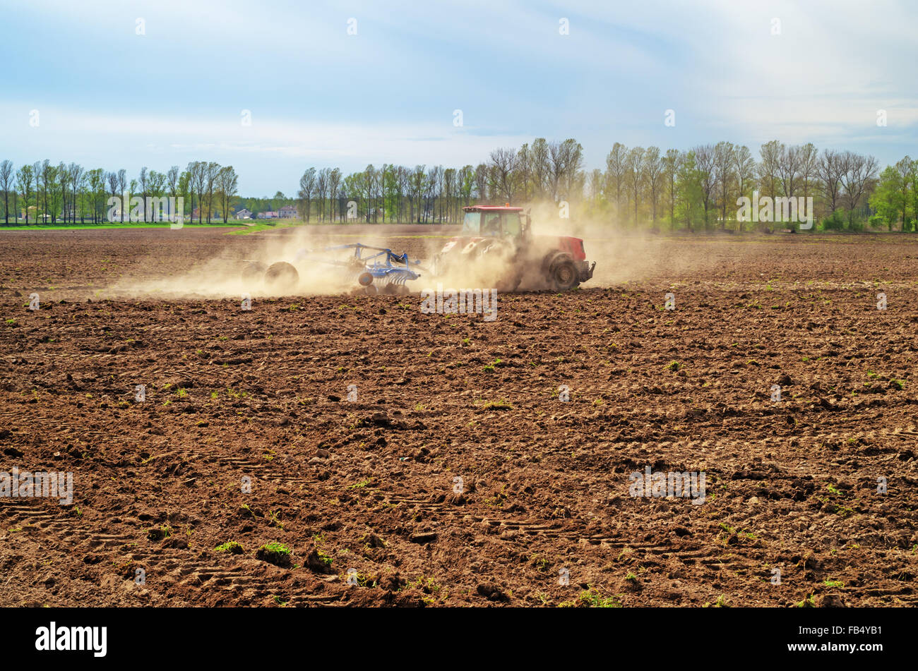 The tractor works at an agricultural field Stock Photo - Alamy