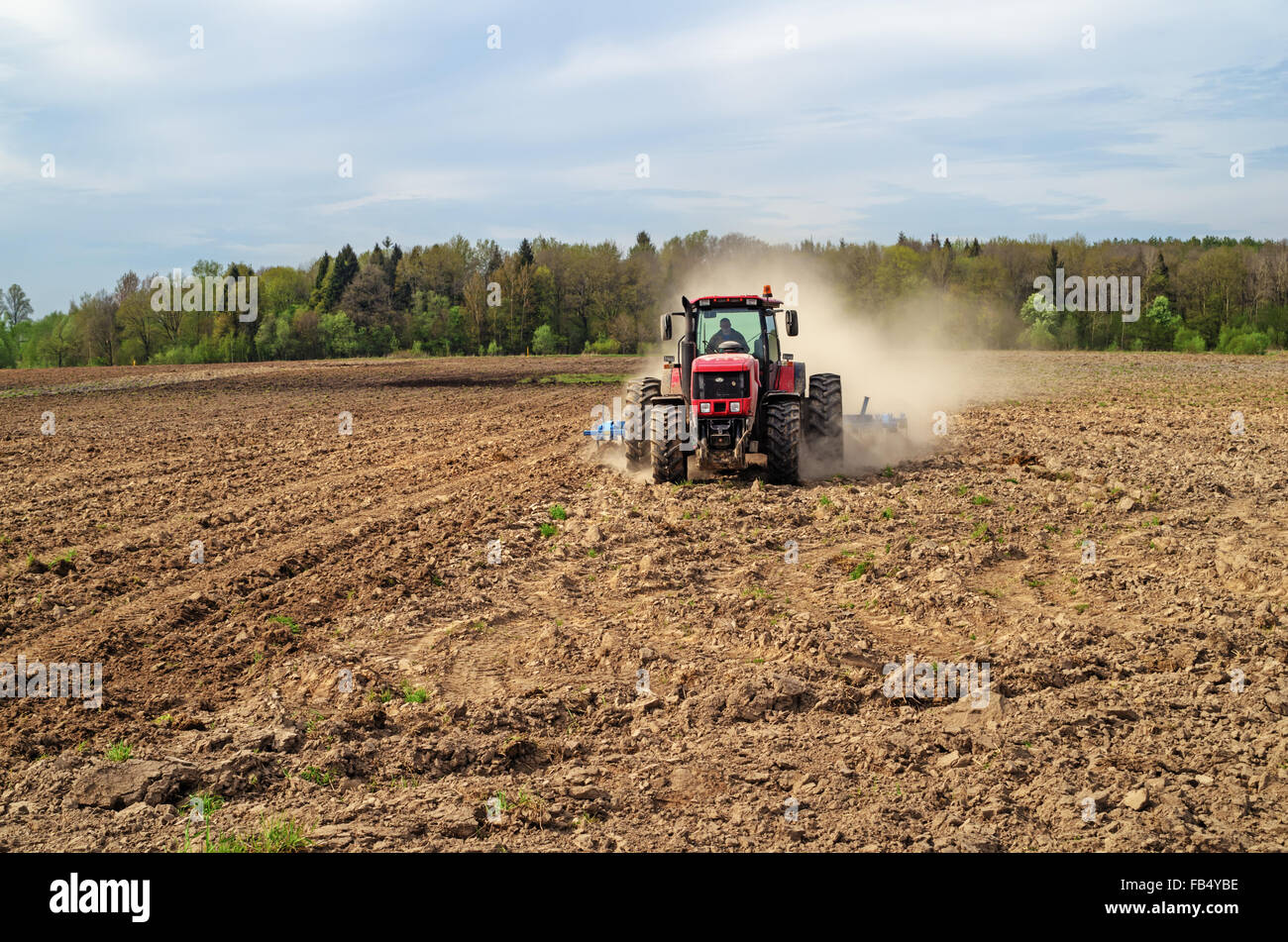 The tractor works at an agricultural field Stock Photo - Alamy