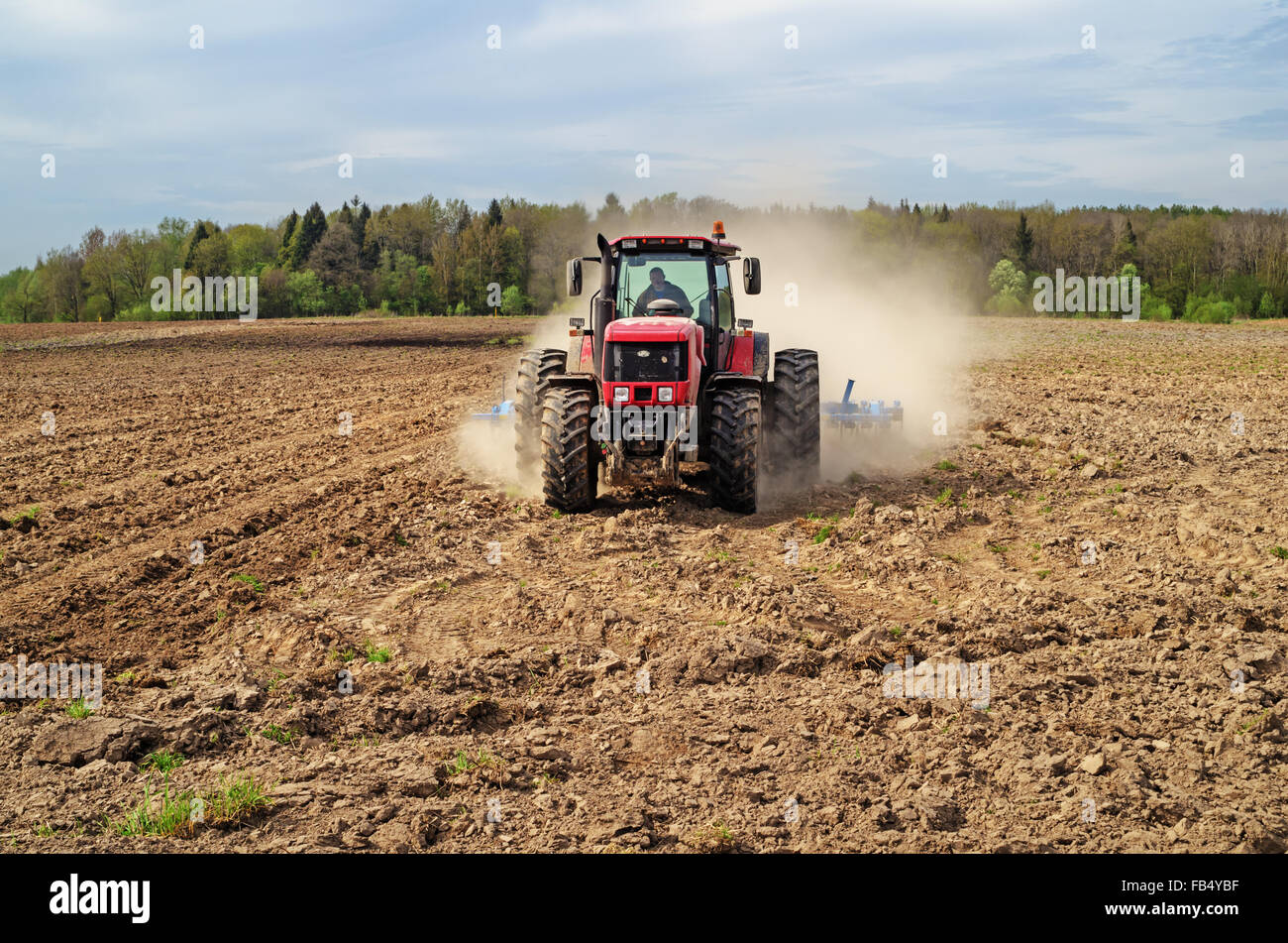 The tractor works at an agricultural field Stock Photo - Alamy