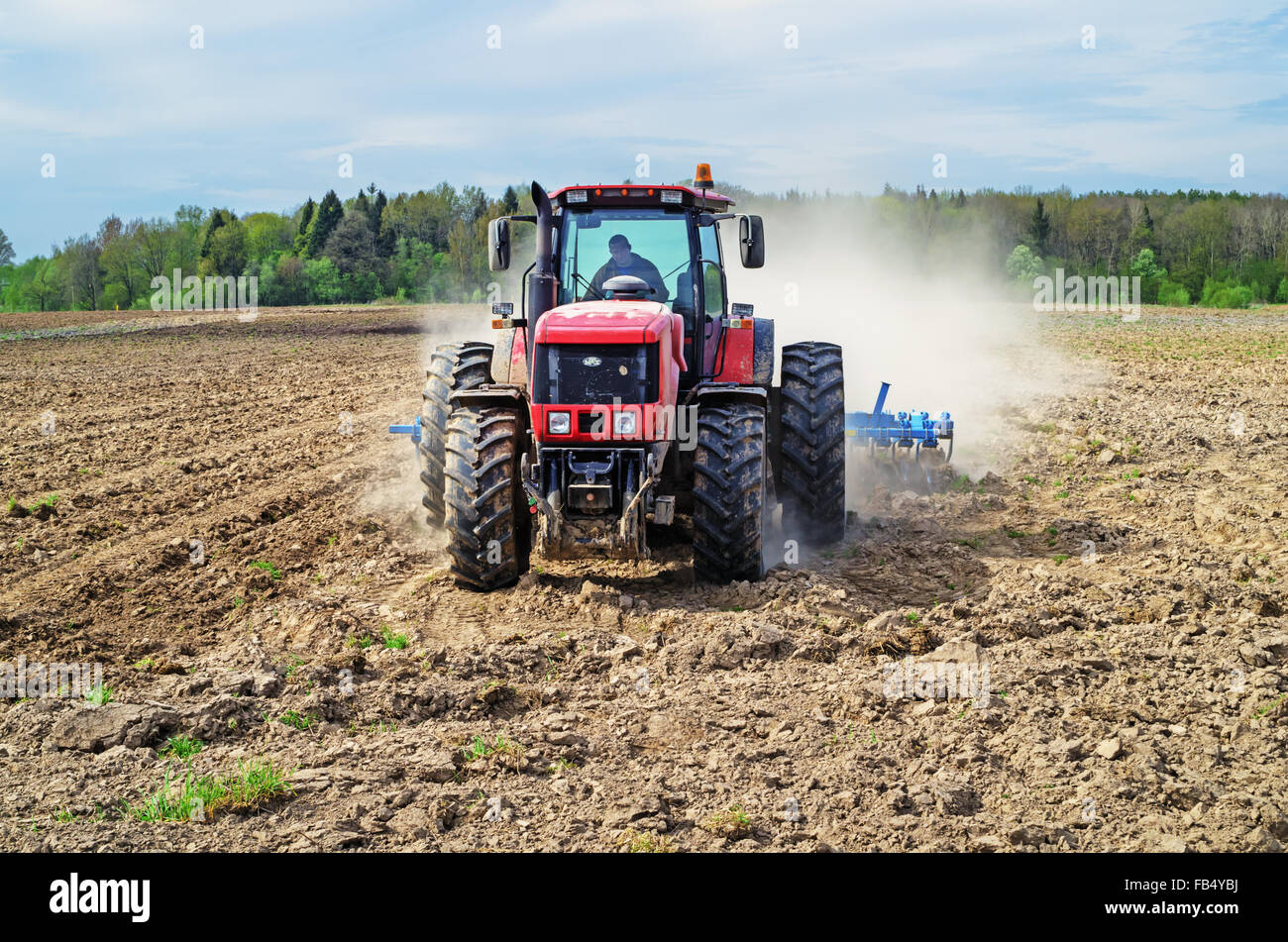 The tractor works at an agricultural field Stock Photo - Alamy