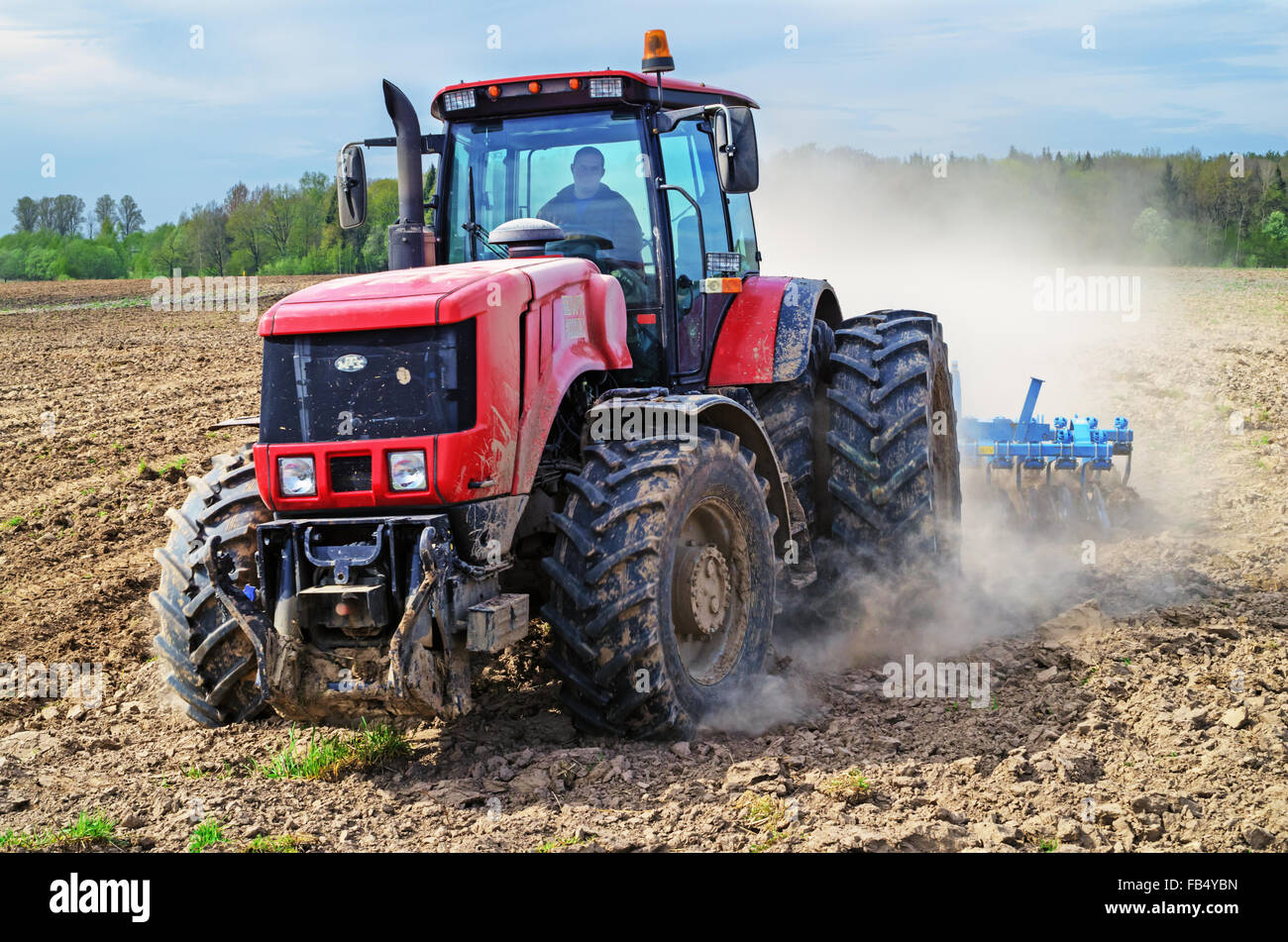 The tractor works at an agricultural field Stock Photo - Alamy