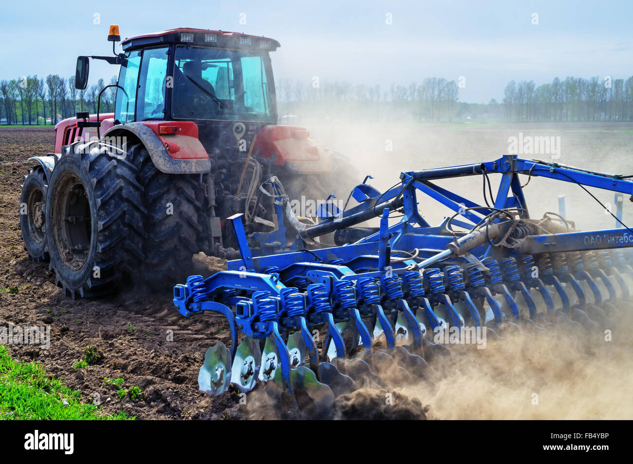The tractor works at an agricultural field Stock Photo - Alamy