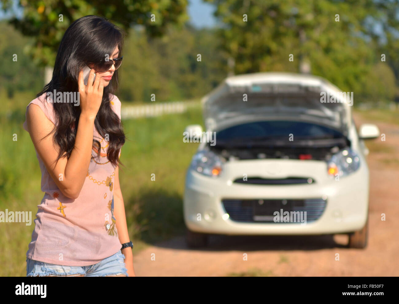 A woman calls for assistance after her car broke down Stock Photo - Alamy