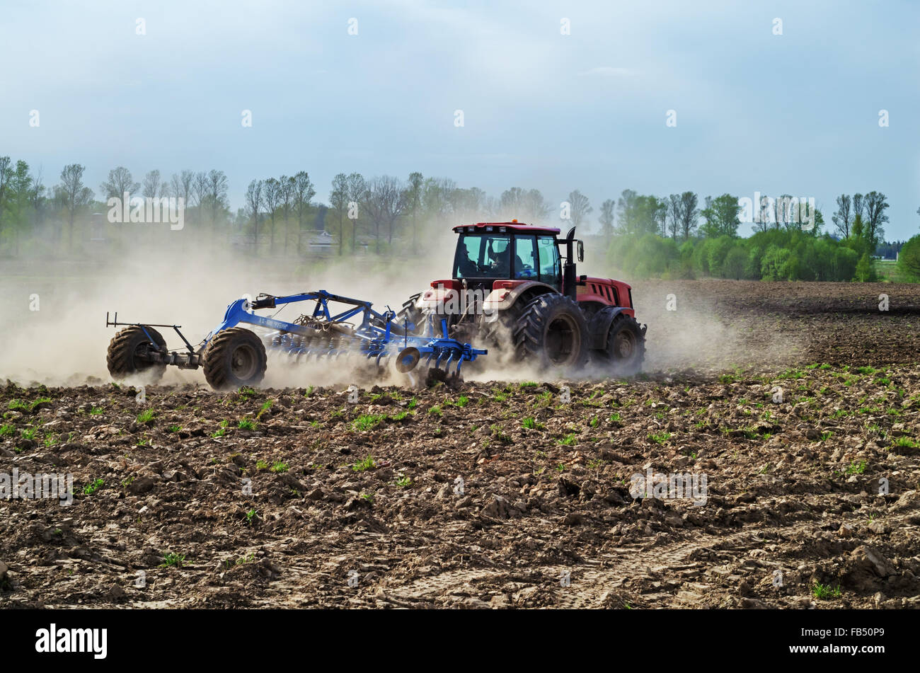 The tractor works at an agricultural field Stock Photo - Alamy
