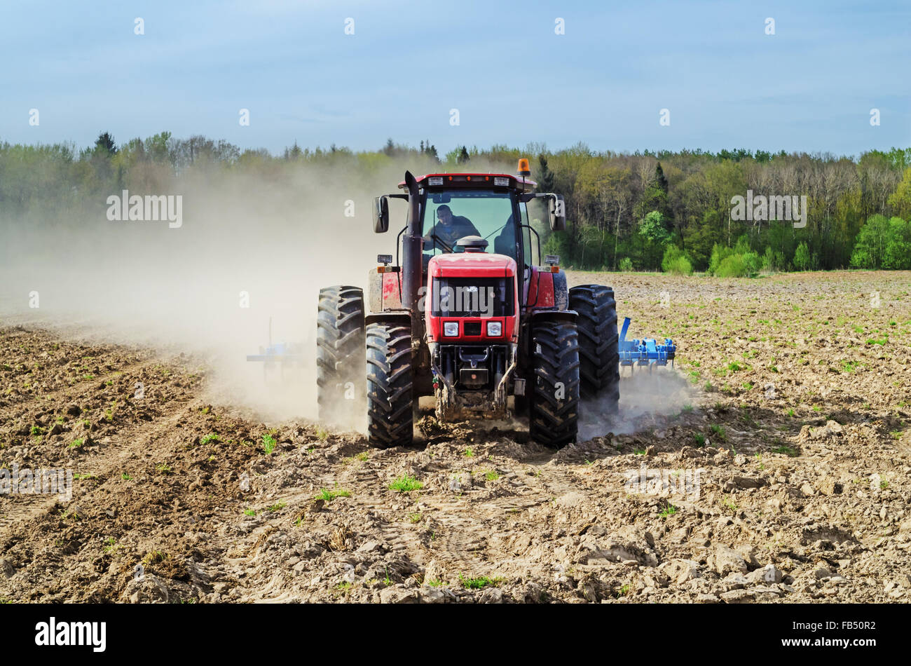 The tractor works at an agricultural field Stock Photo - Alamy