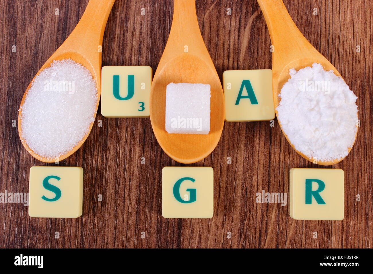 Sugar cube, granulated and powdered sugar on wooden spoons with text ...