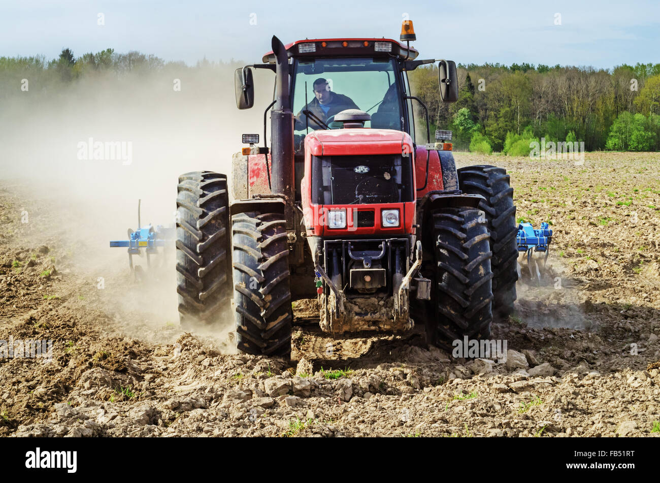 The tractor works at an agricultural field Stock Photo - Alamy
