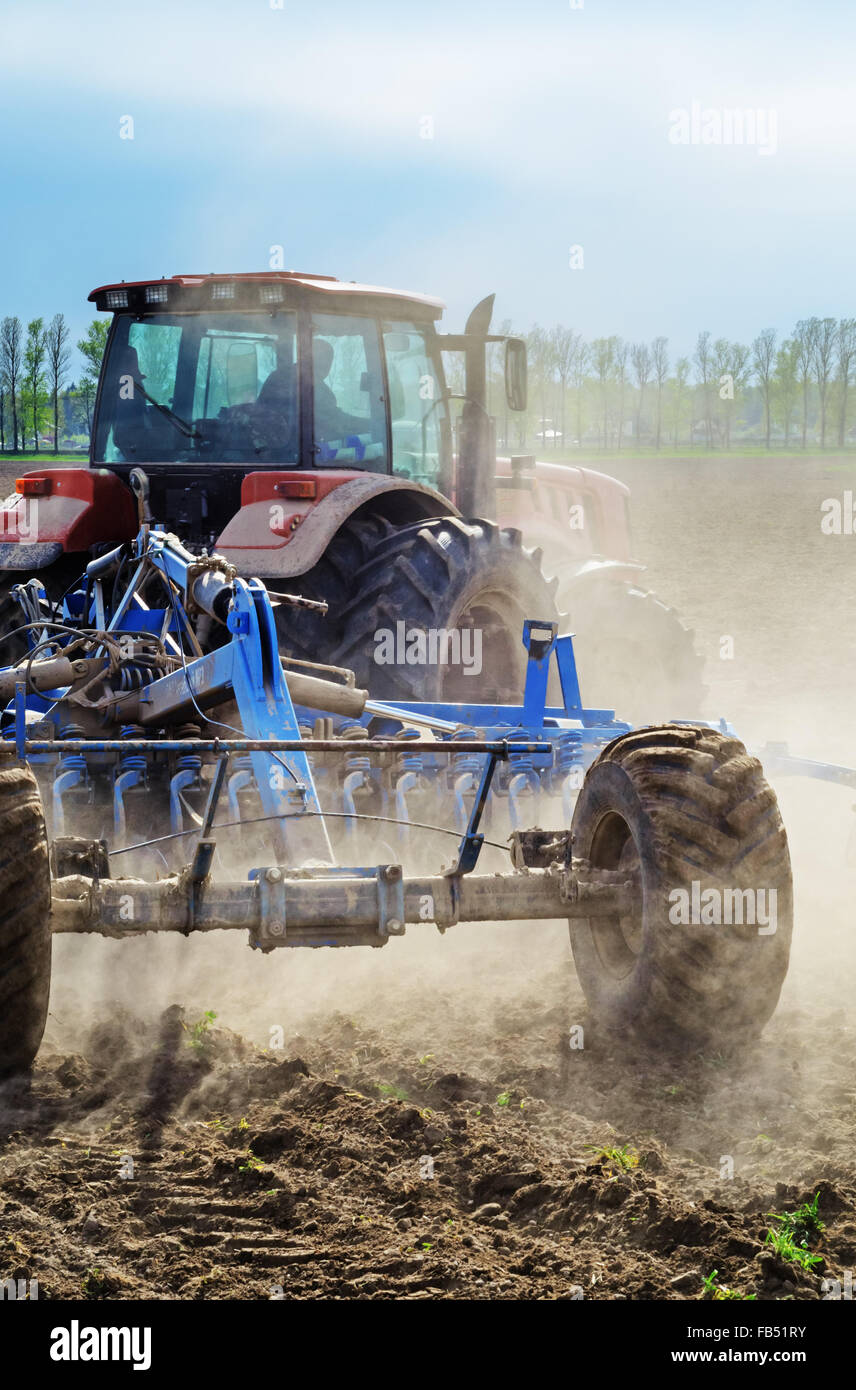 The tractor works at an agricultural field Stock Photo - Alamy
