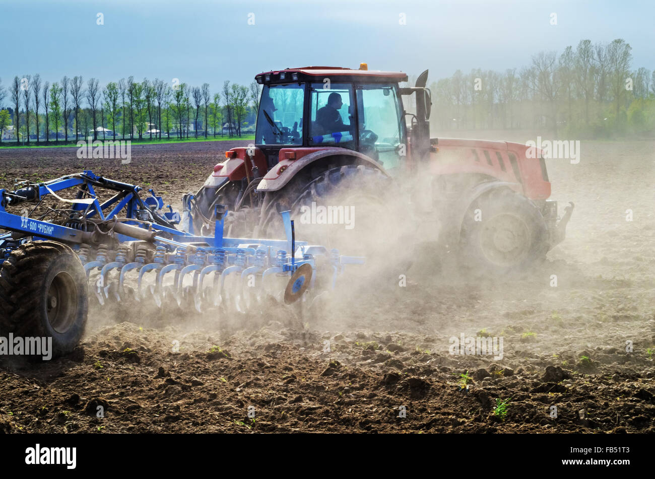 The tractor works at an agricultural field Stock Photo - Alamy