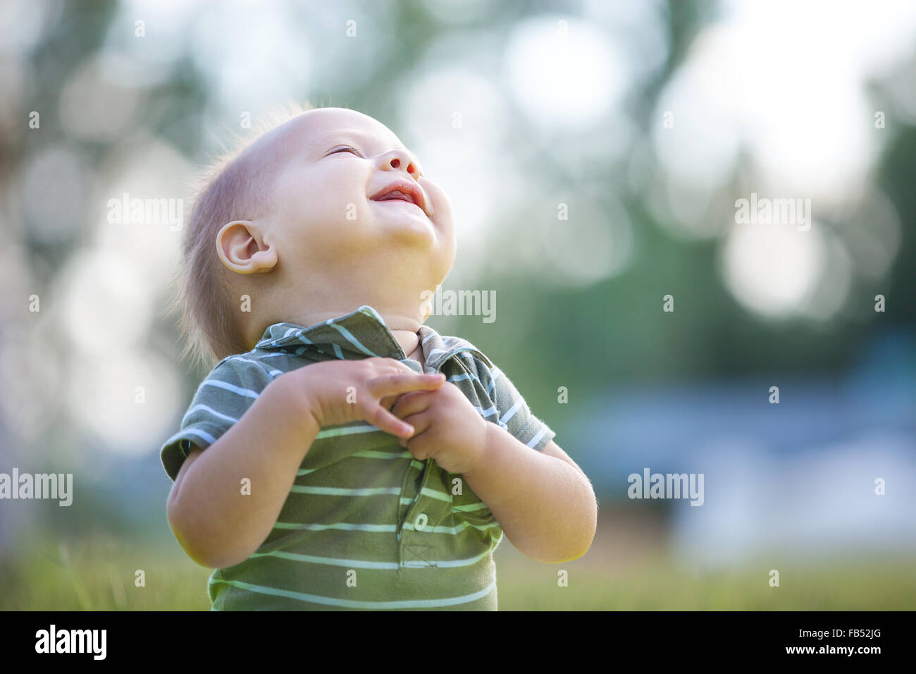 Baby boy looking up in the park Stock Photo - Alamy