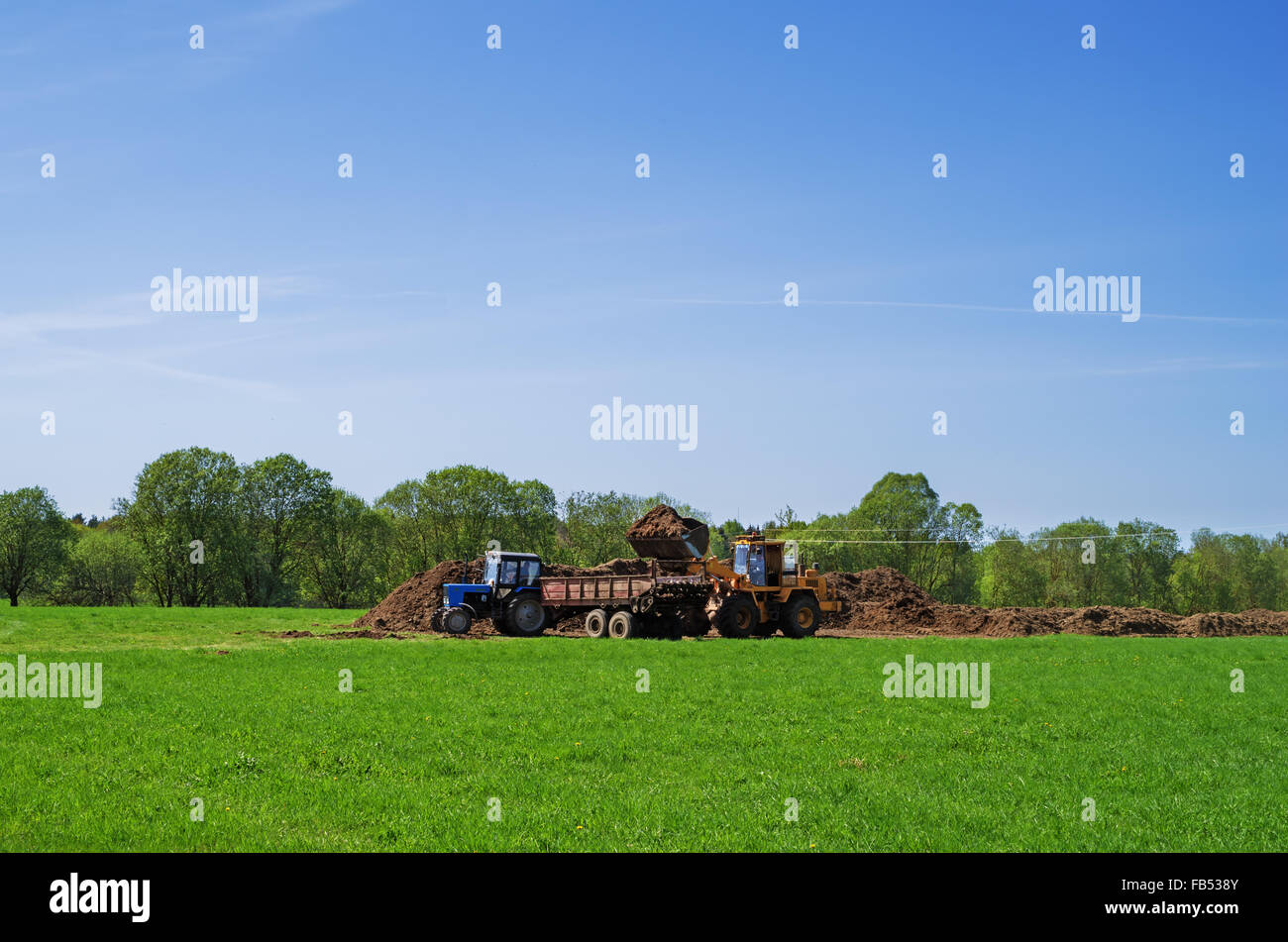 The tractor works at an agricultural field Stock Photo - Alamy
