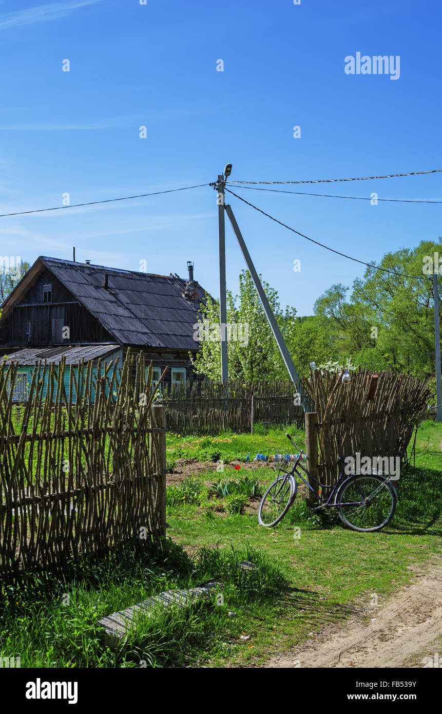 Village landscape with branch fence and bicycle Stock Photo - Alamy