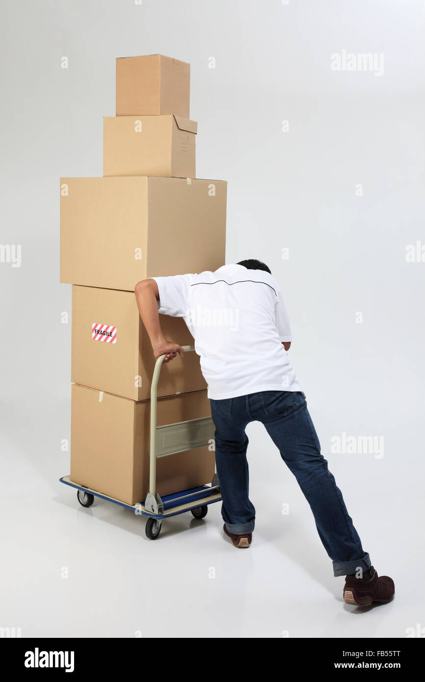 delivery man pushing a trolley with boxes Stock Photo - Alamy