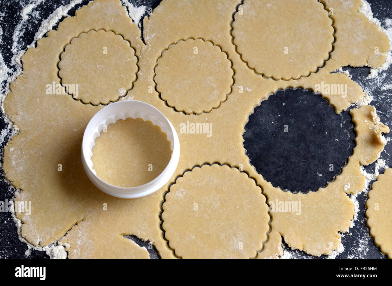 Rolled out dough with a cookie cutter and several circles cut, on a ...
