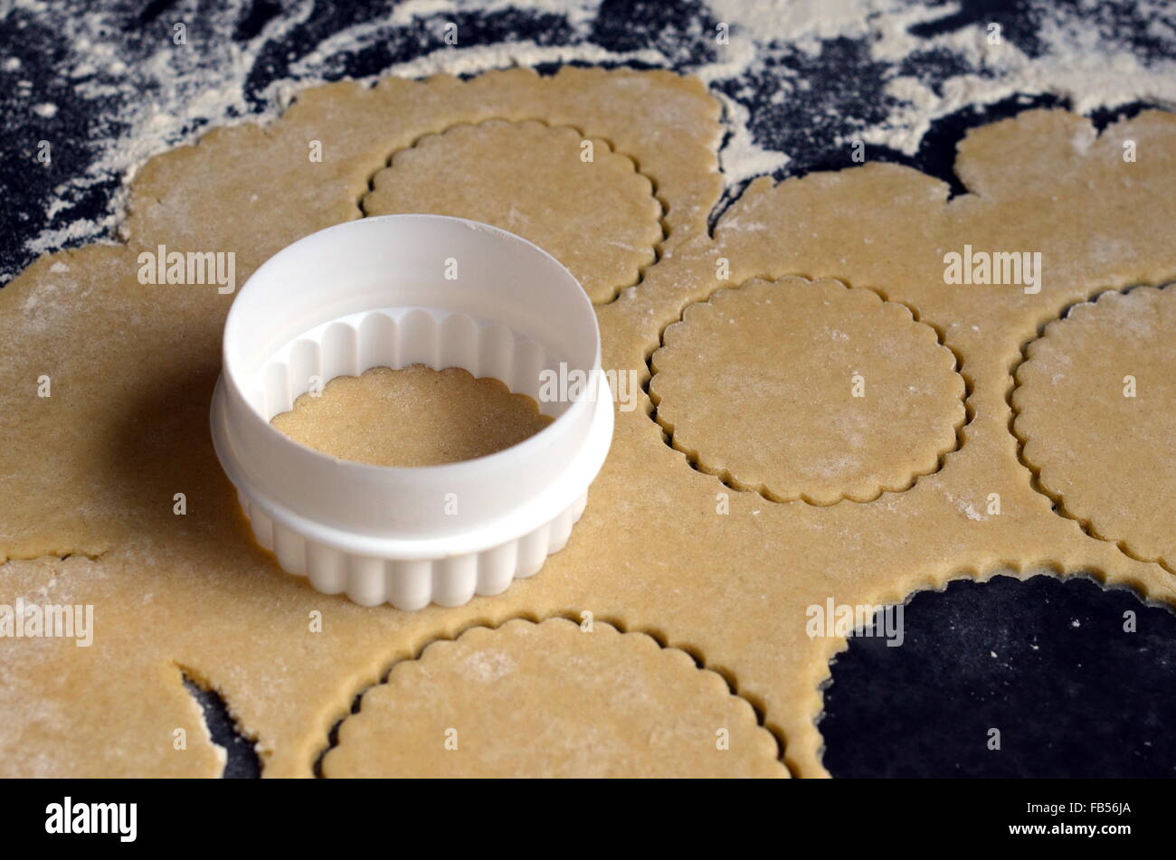 Rolled out dough with a cookie cutter and several circles cut, on a ...