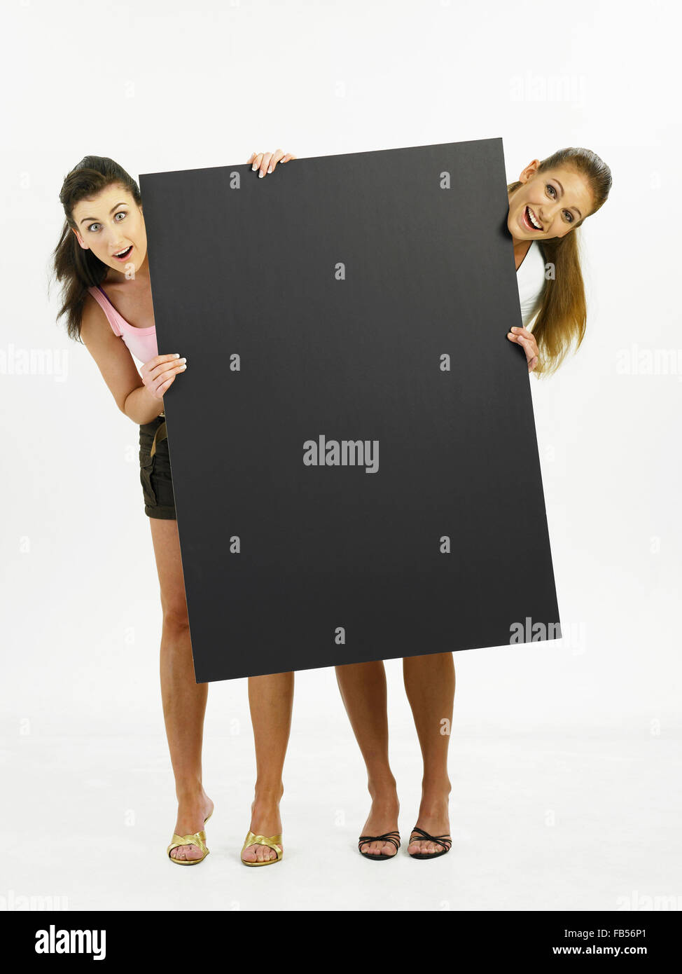 two woman holding a big size card Stock Photo - Alamy